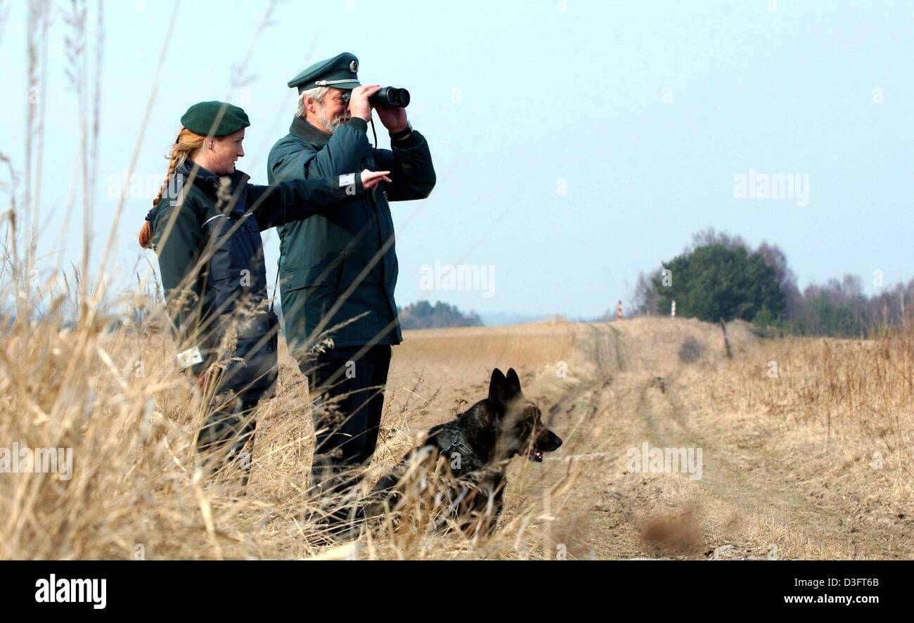 (dpa) - Two German customs officers and their dog observe the ...