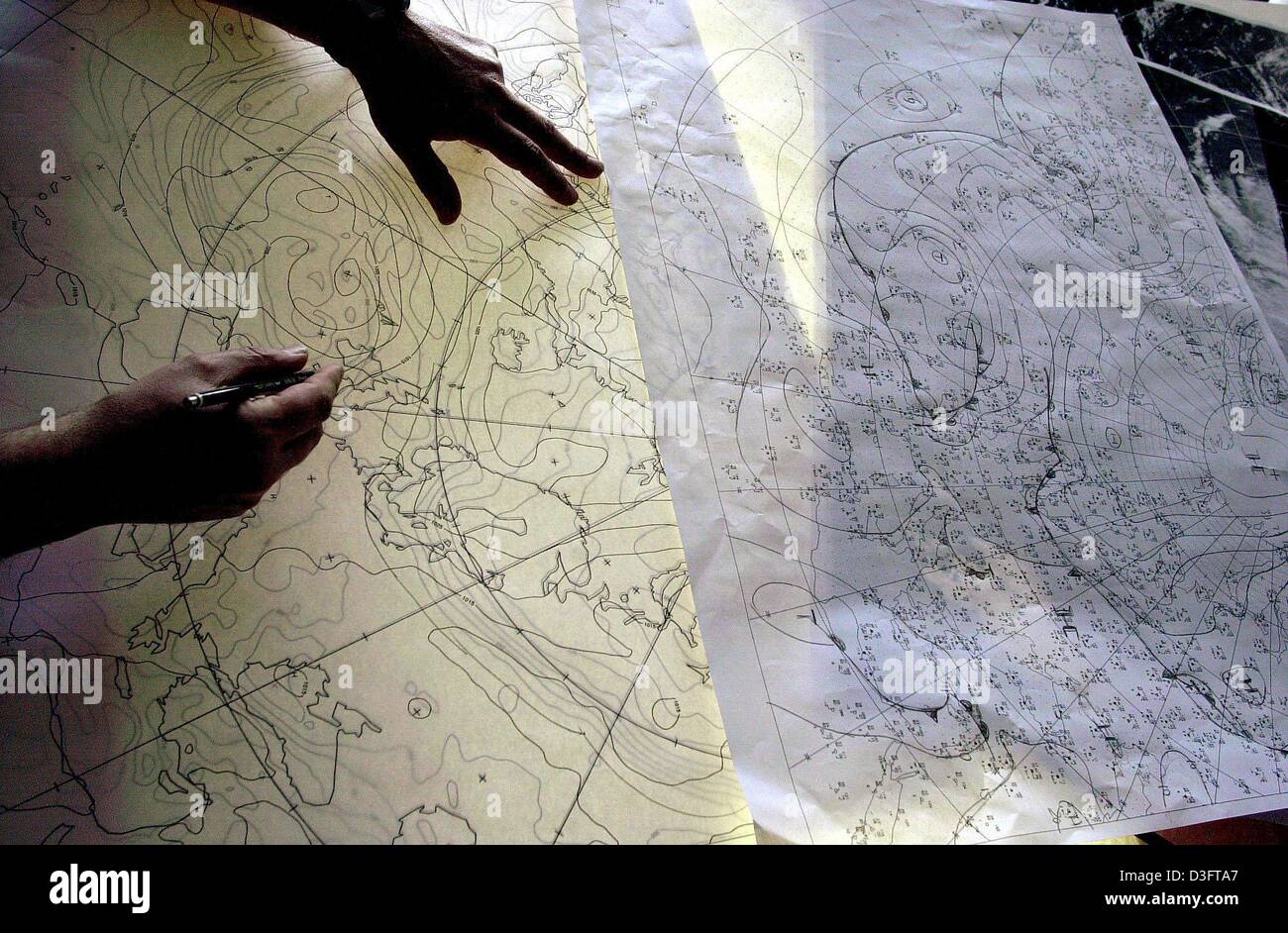 (dpa) - The hands of a meteorologist move across a weather chart in the ...