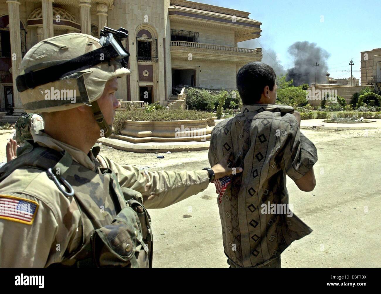 (dpa) - A US soldier guards an arrested looter near the Jidriye palaces ...