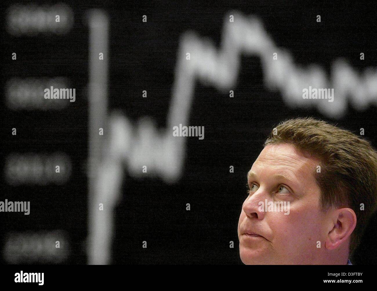 (dpa) - A stockbroker looks at the display of the German stock exchange ...