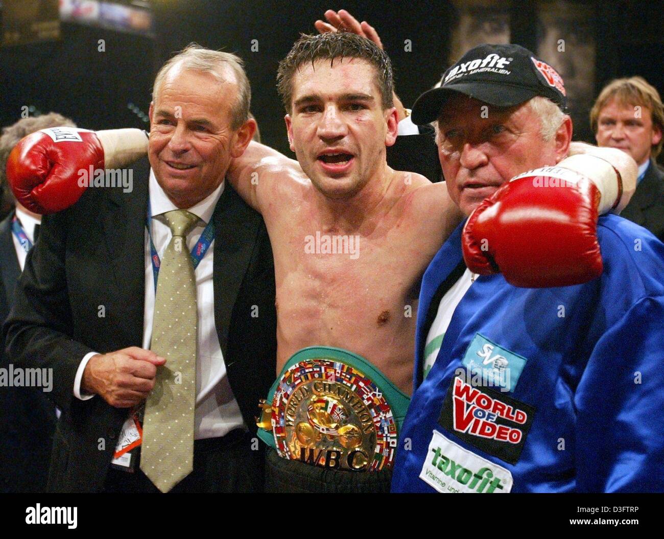 (dpa) - German challenger Markus Beyer (C) wears the champions' belt ...