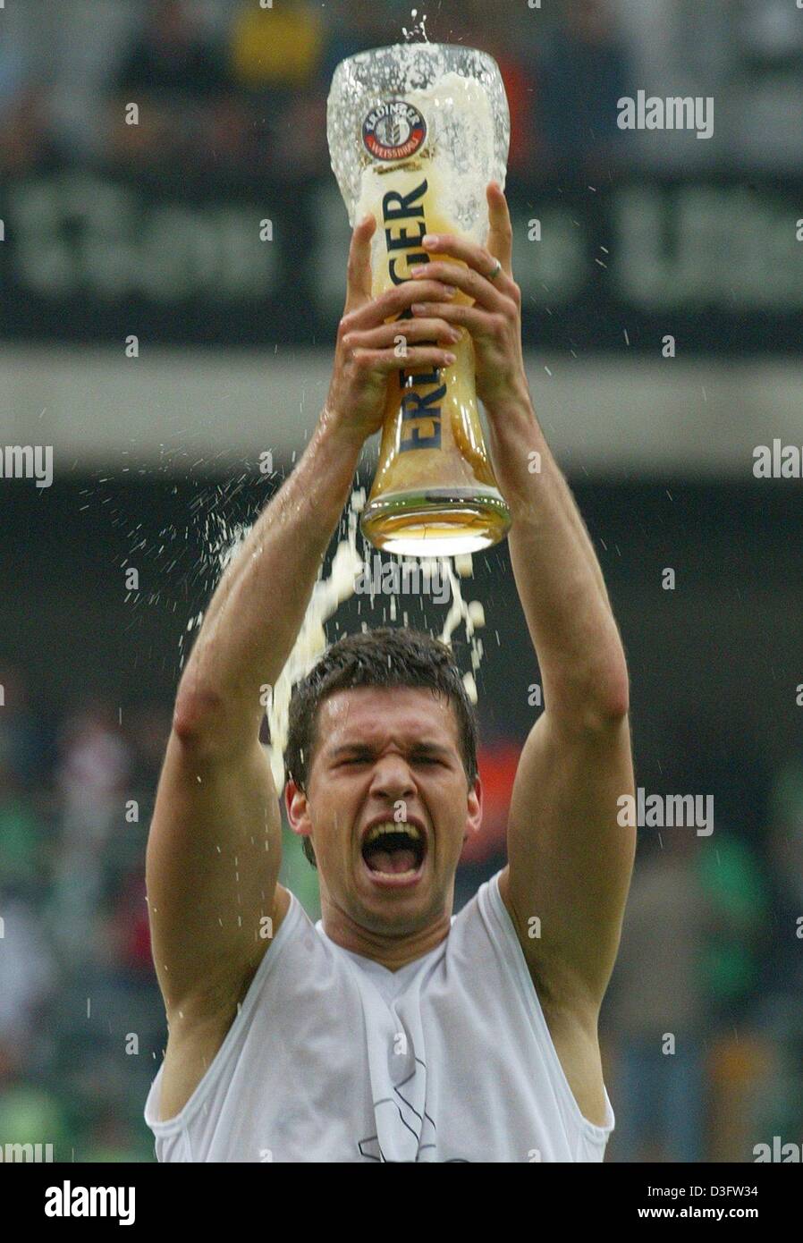(dpa) - Bayern's midfielder Michael Ballack holds up a huge glass of ...