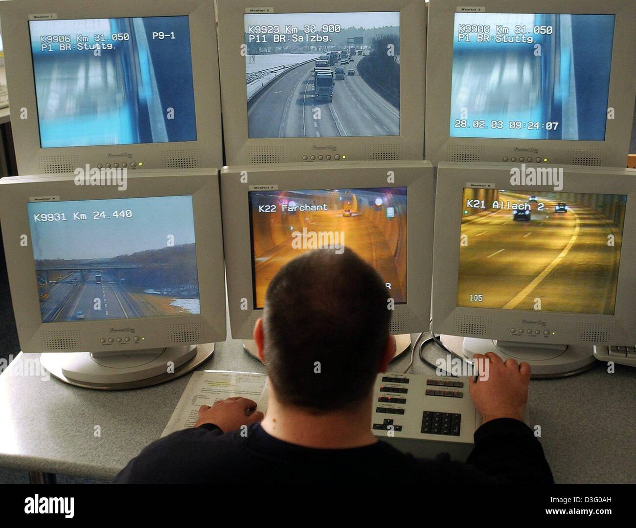 (dpa) - An employee sits in front of computer screens on which he can ...