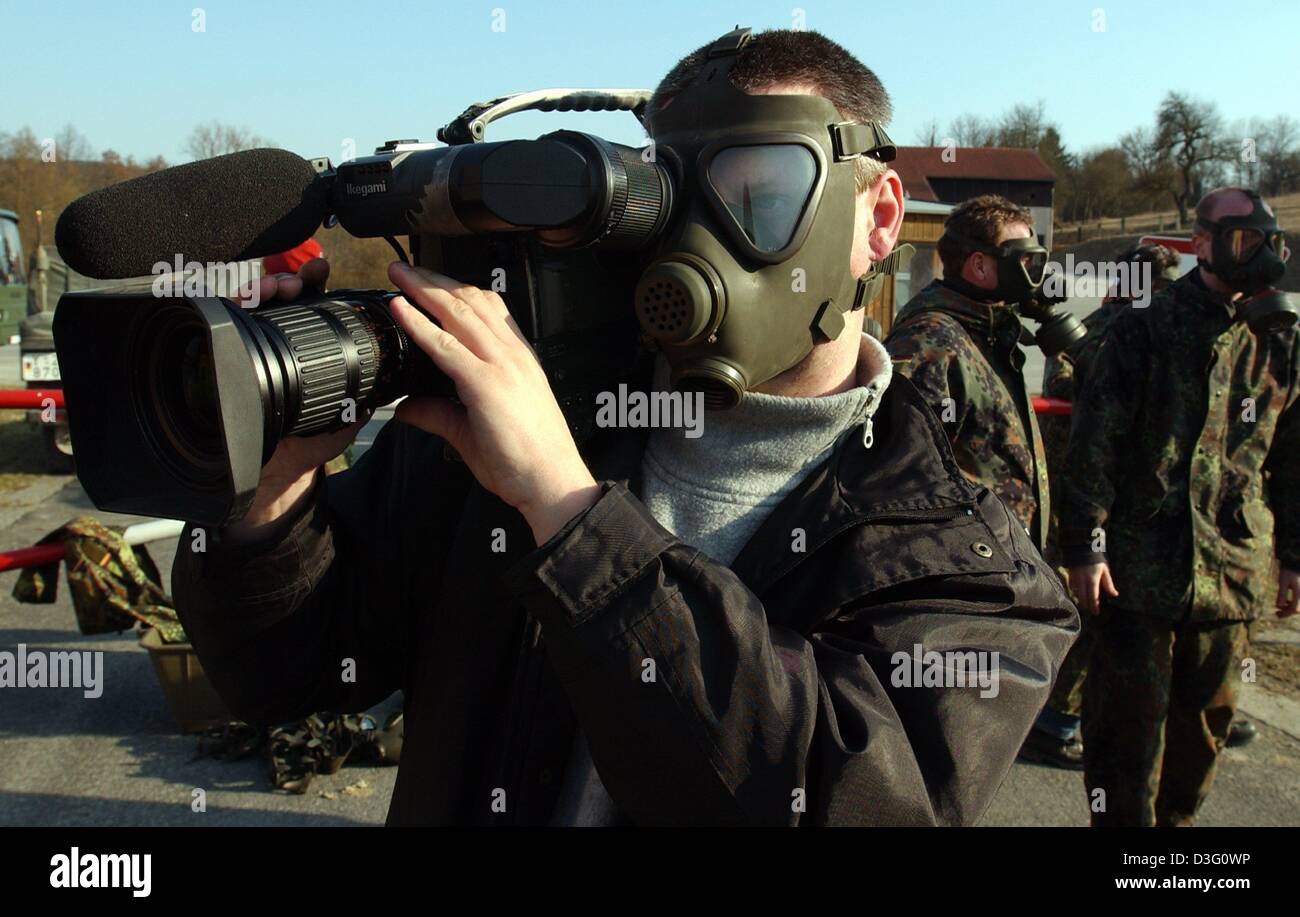 (dpa) - A cameraman wears a gas mask and carries a camera on his ...