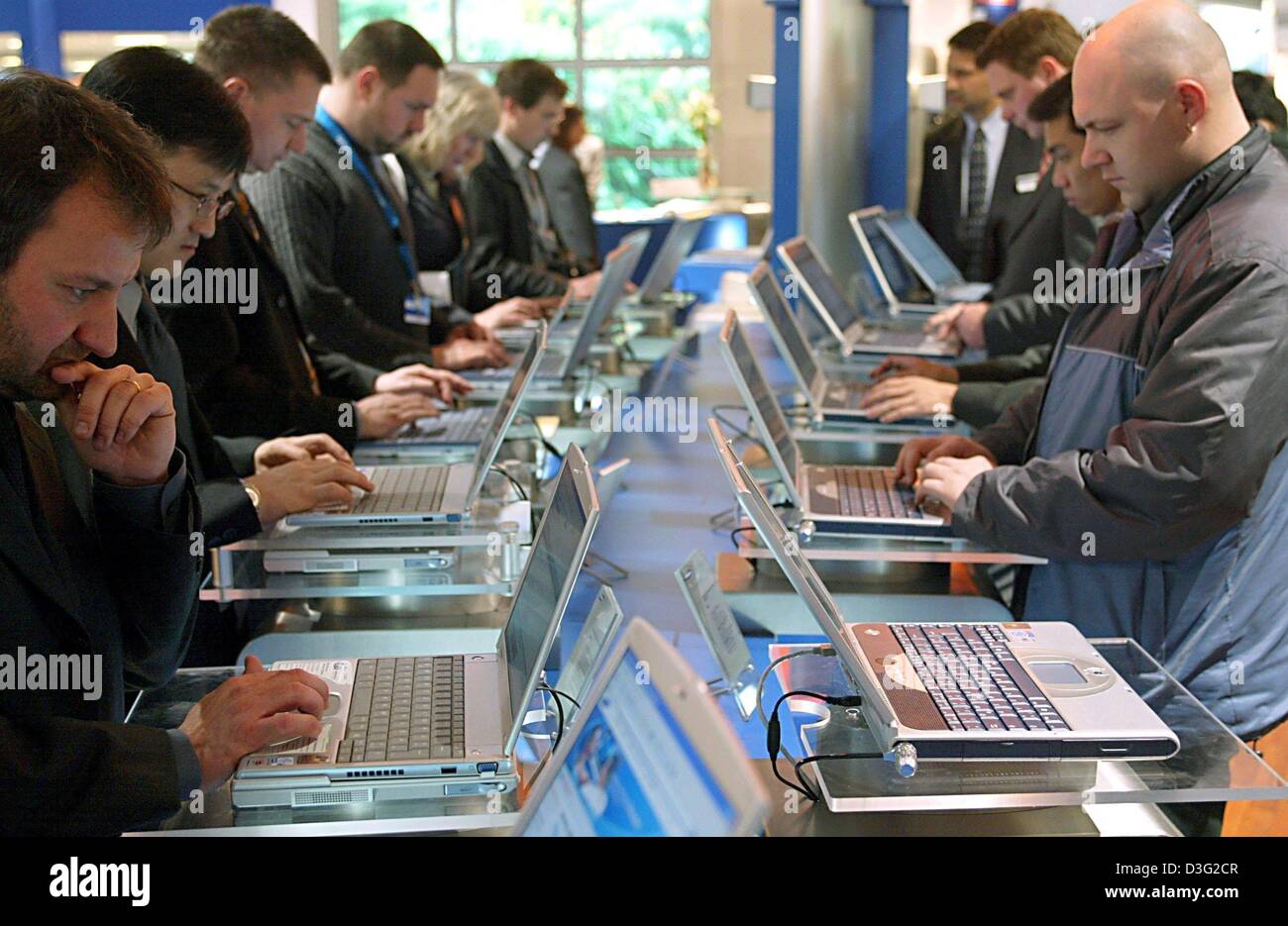 (dpa) - A visitor stands in front of laptop computers and look ...