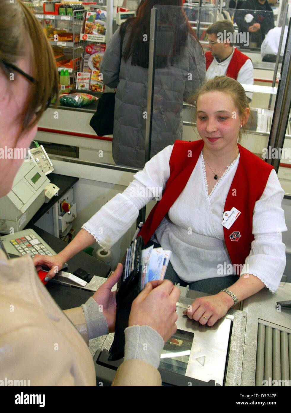 (dpa) - A customer pays cash at a cash desk in an Intermarche ...
