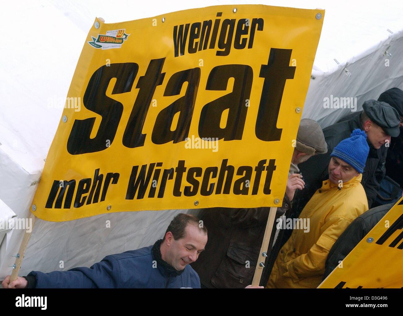 (dpa) - German craftsmen carrying a poster which reads 'less state ...