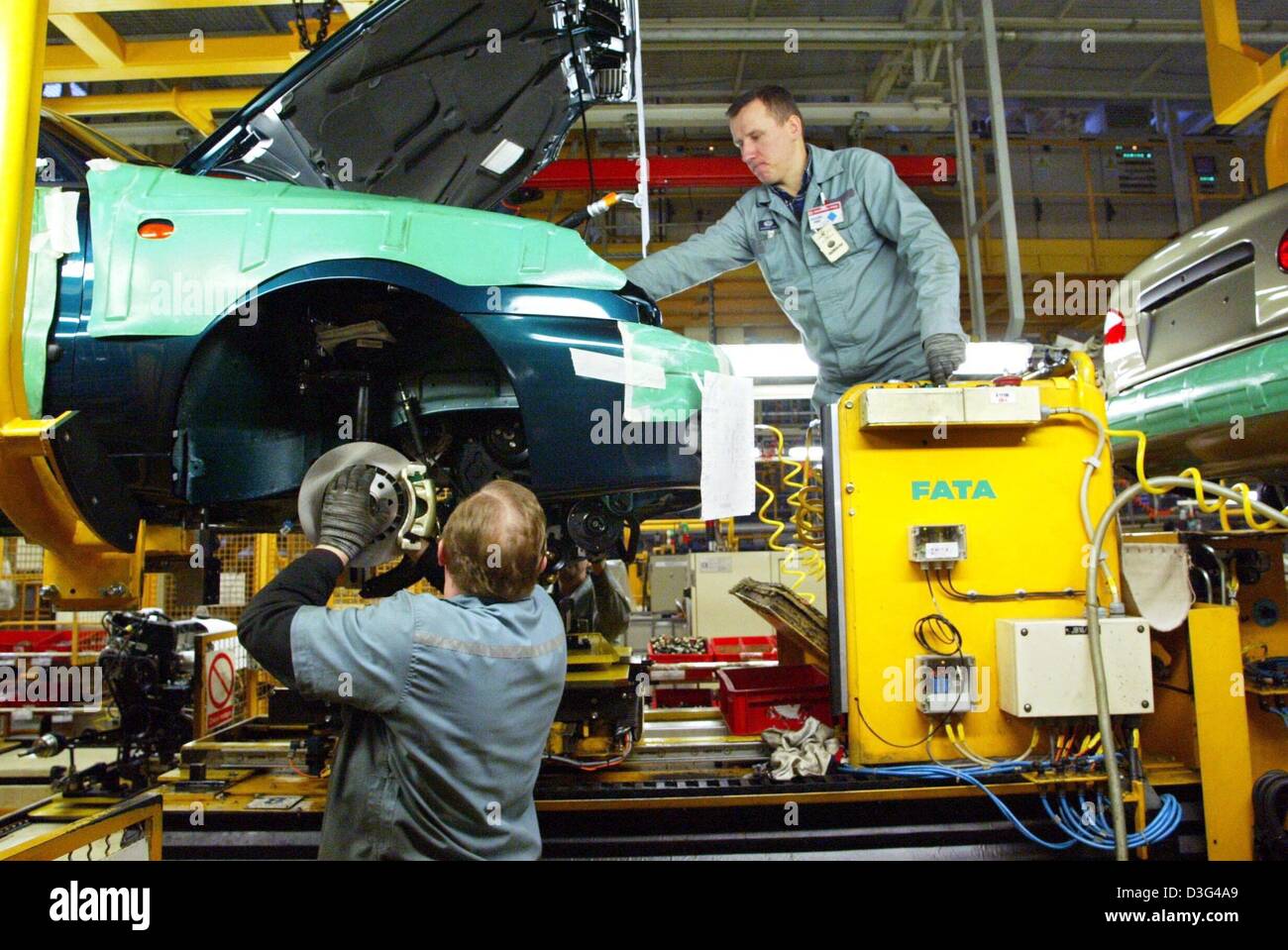 (dpa) - Workers assemble car body parts in a factory of the South ...