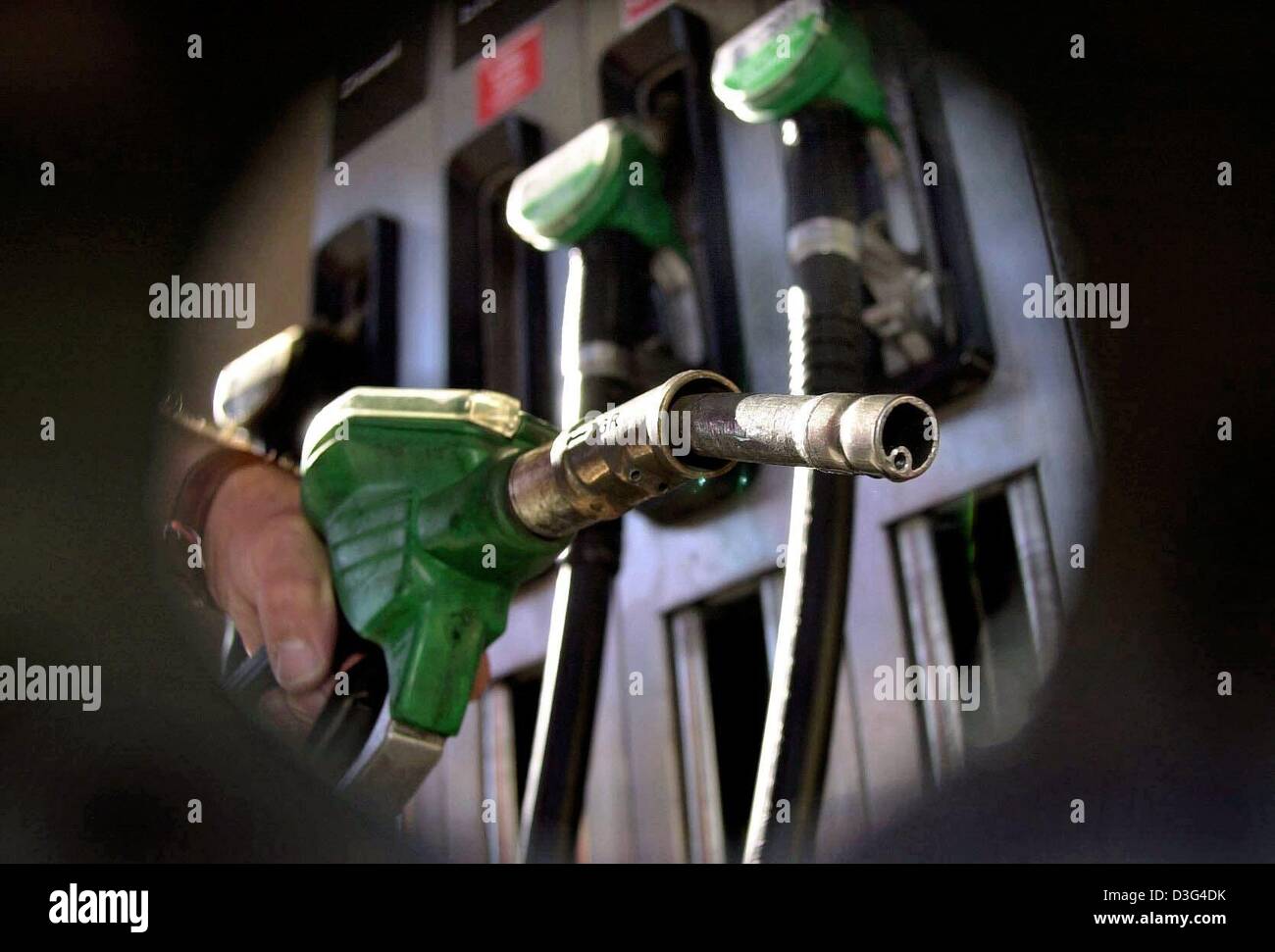 (dpa files) - A hand holds the filler plug of a petrol pump at a ...