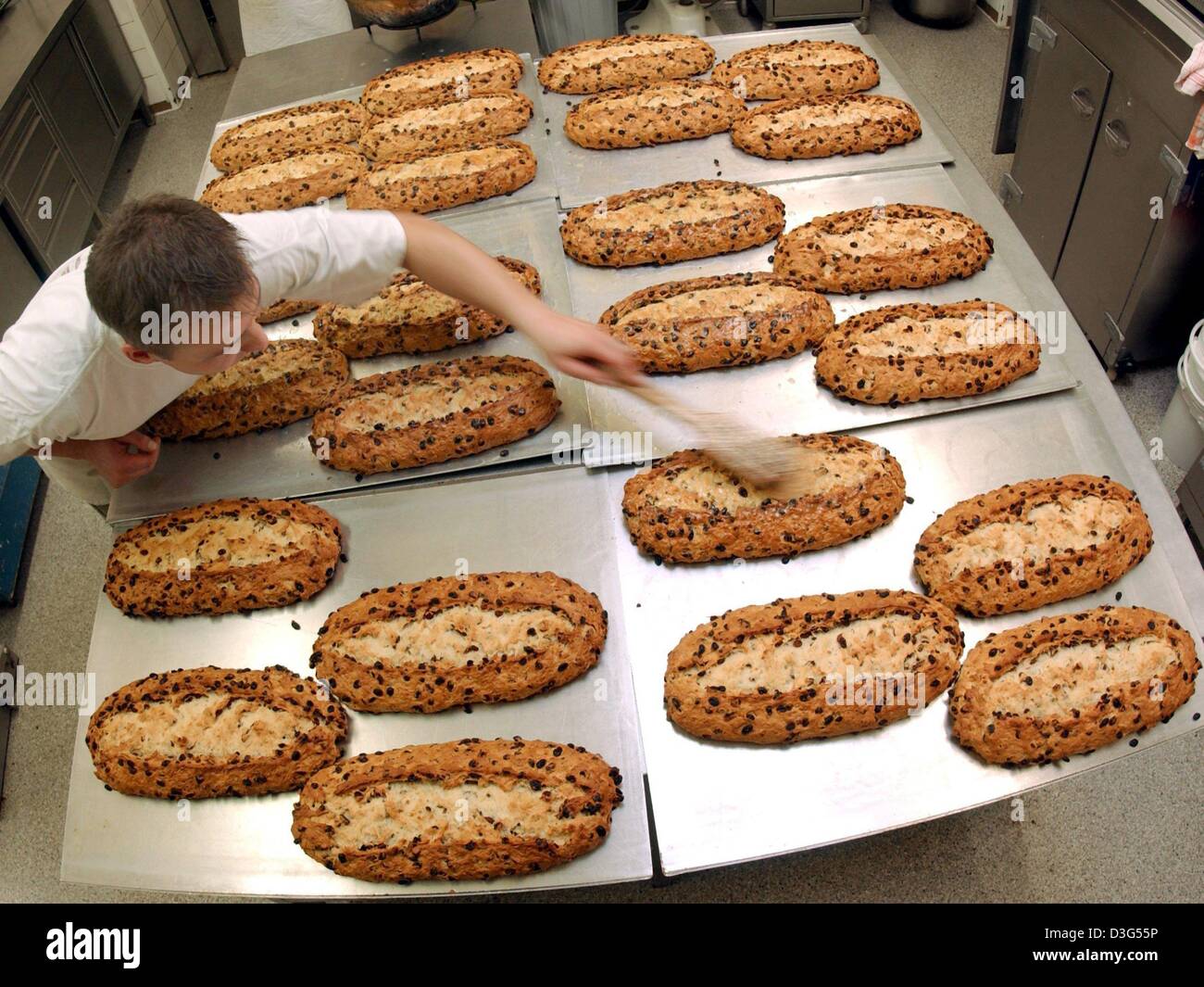 (dpa) - A baker butters the traditional Christmas stollens at the ...