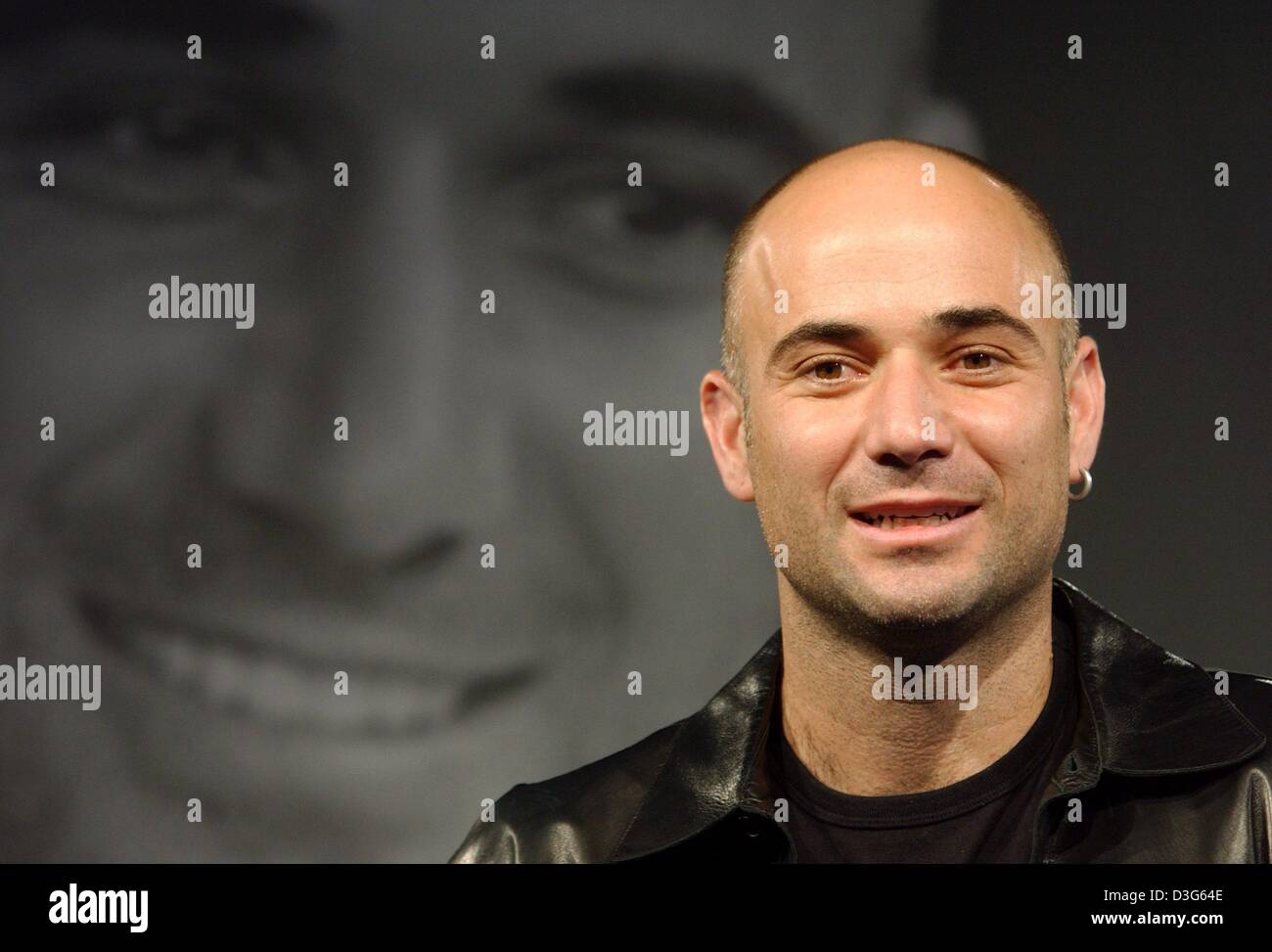 (dpa) - US tennis pro Andre Agassi stand in front of an oversized ...