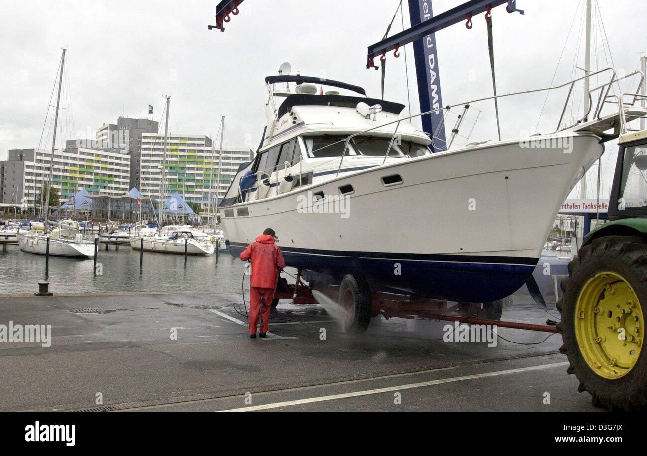 (dpa) - A marina worker sprays a motor yacht with water in preparation ...