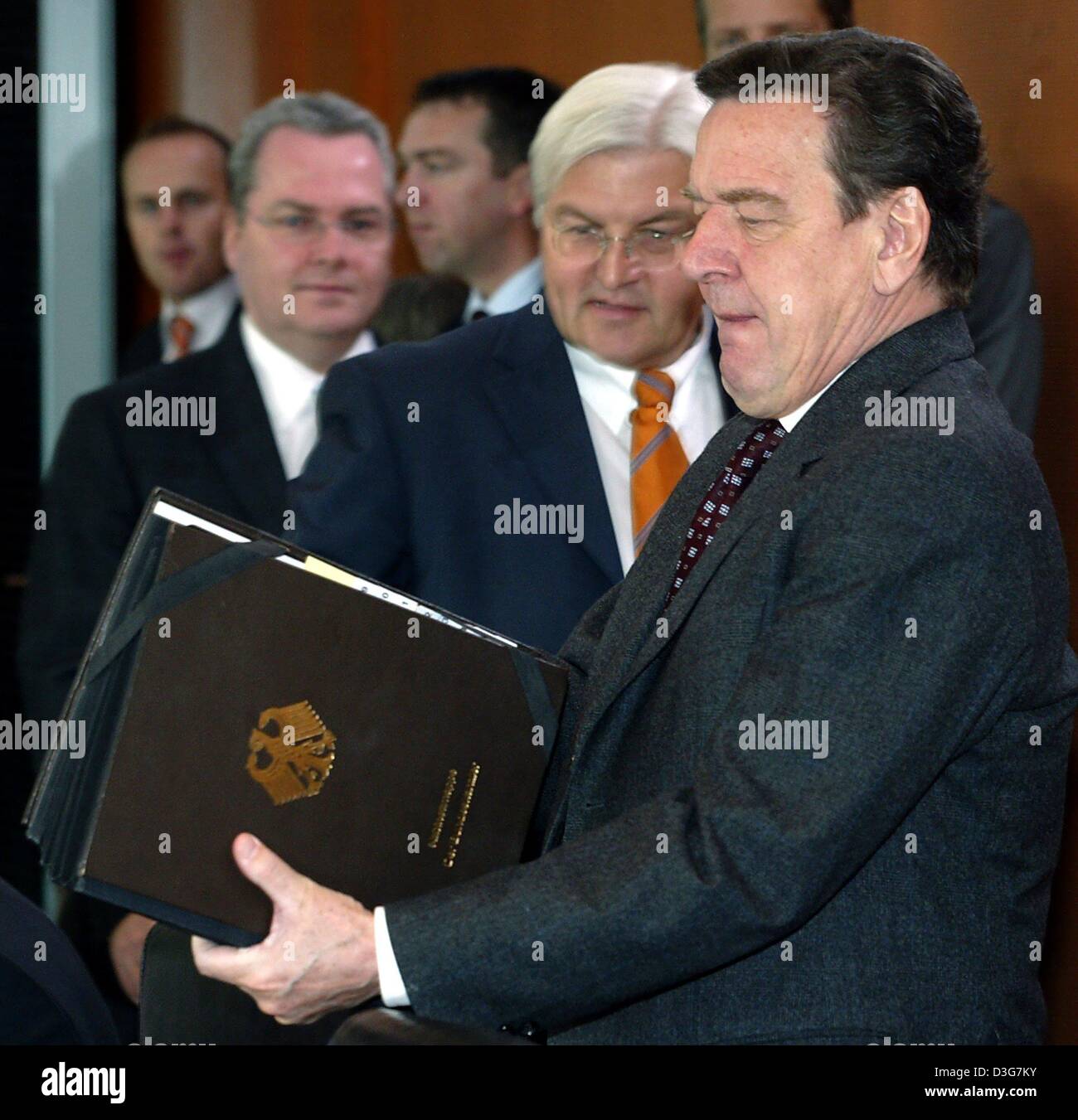 (dpa) - German Chancellor Gerhard Schroeder (R) carries his briefcase ...