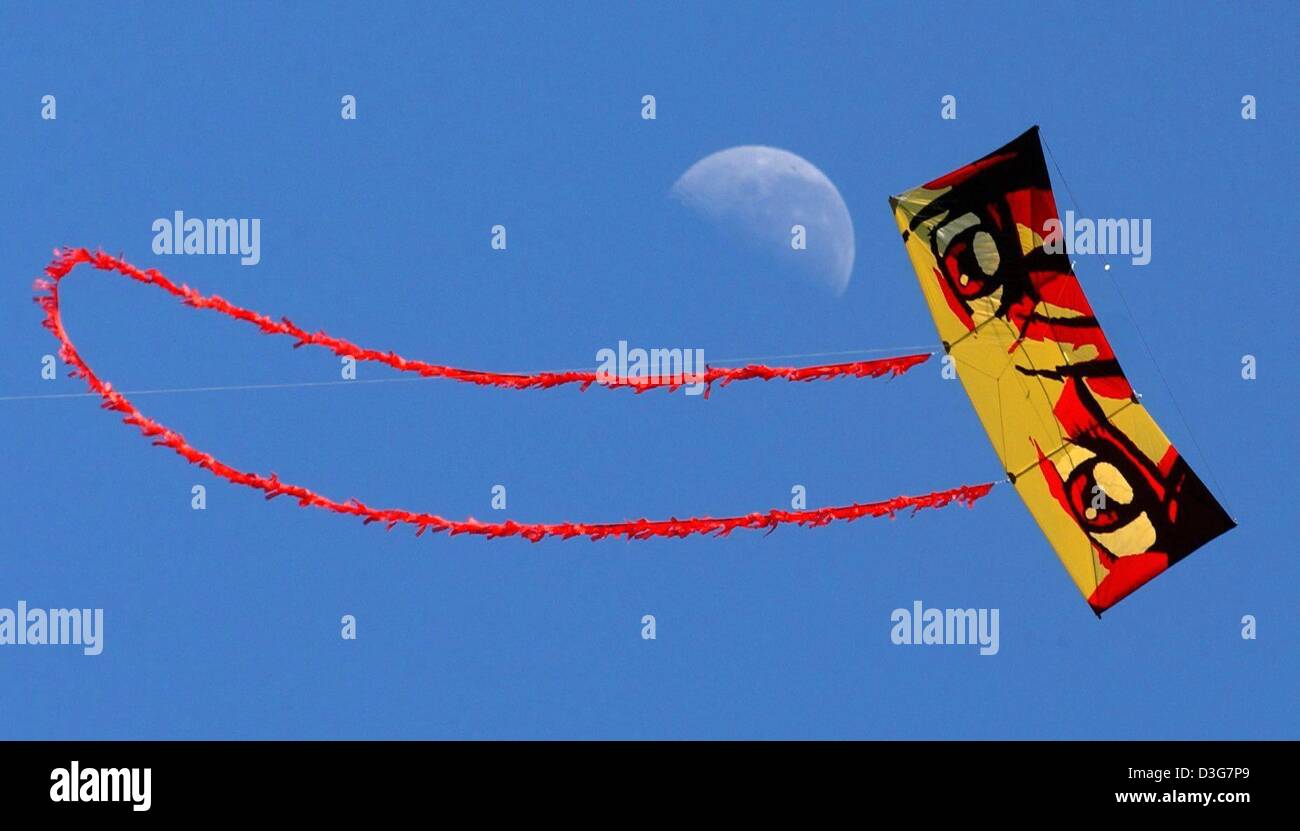 (dpa) - A kite with eyes is flying in front of the moon at the kite ...