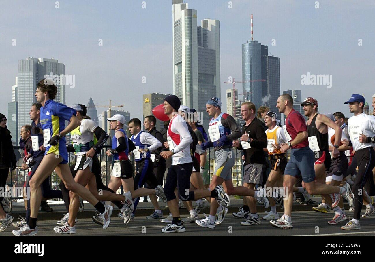 (dpa) - Marathon runners run across a bridge past the skyline of ...