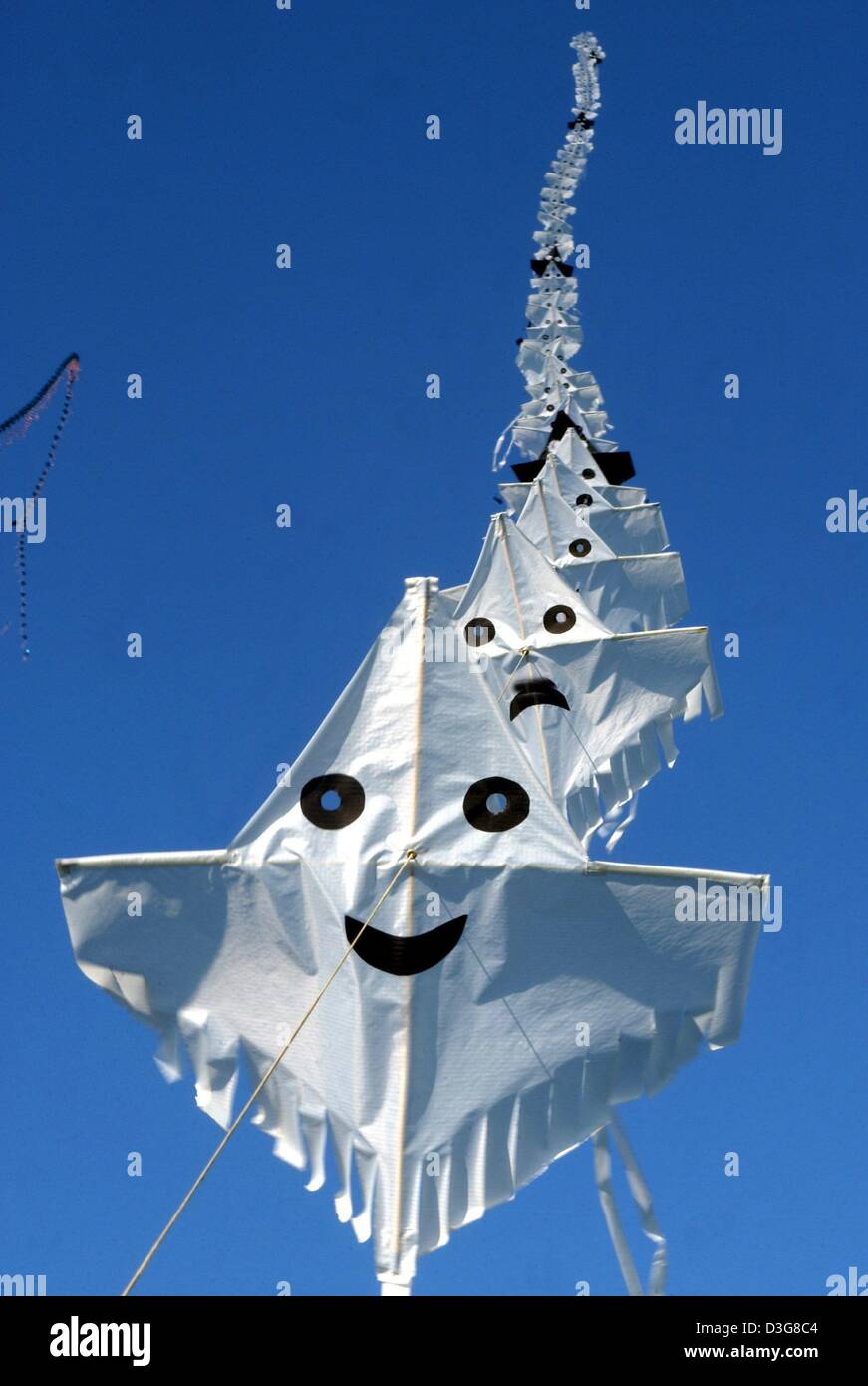 (dpa) - A chain of kites with ghost faces is flying in front of the ...