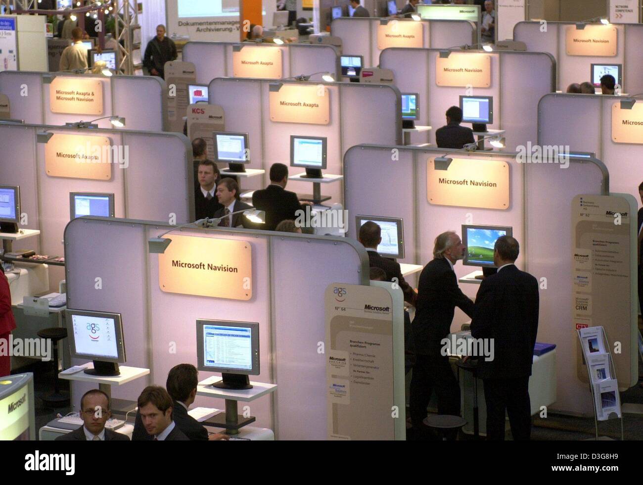 (dpa) - Visitors look at computer screens at the Microsoft stand at the ...