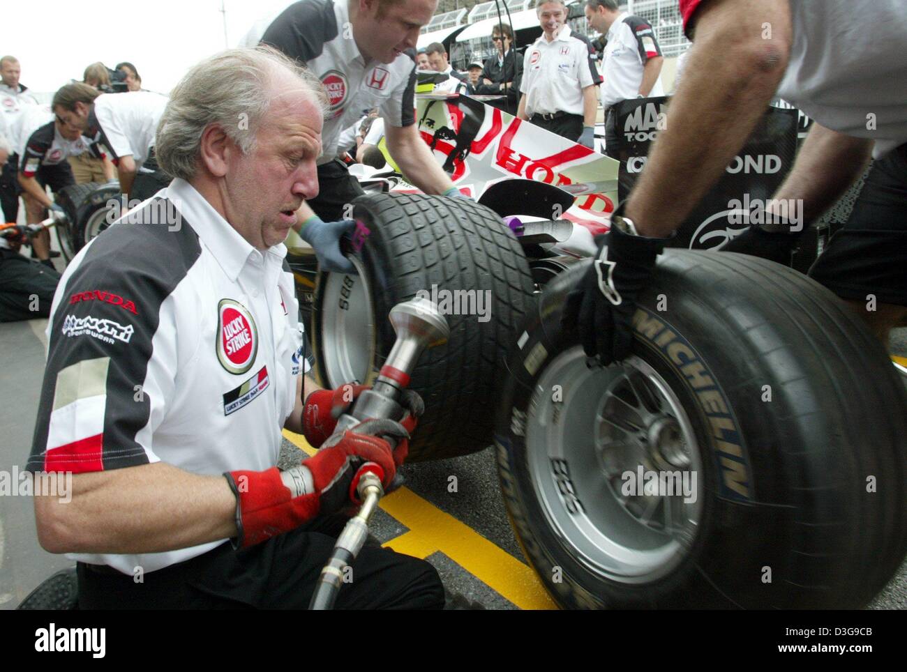 (dpa) - BAR-Honda team chief David Richards (L) tries to change a tyre ...