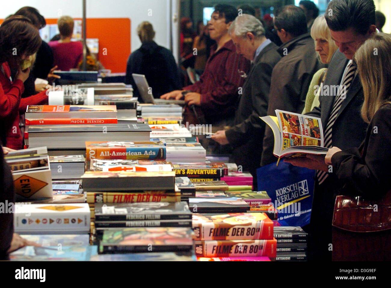 (dpa) - Visitors look through piles of books at the Frankfurt Book Fair ...