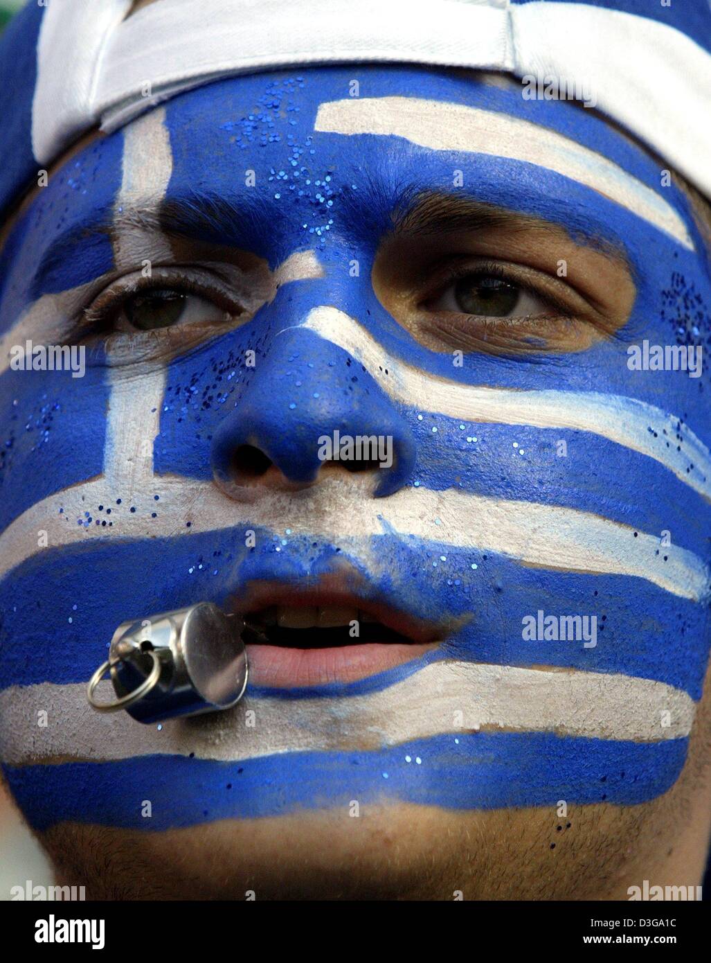 (dpa) - A Greek soccer fan with the Greek flag painted on his face and ...