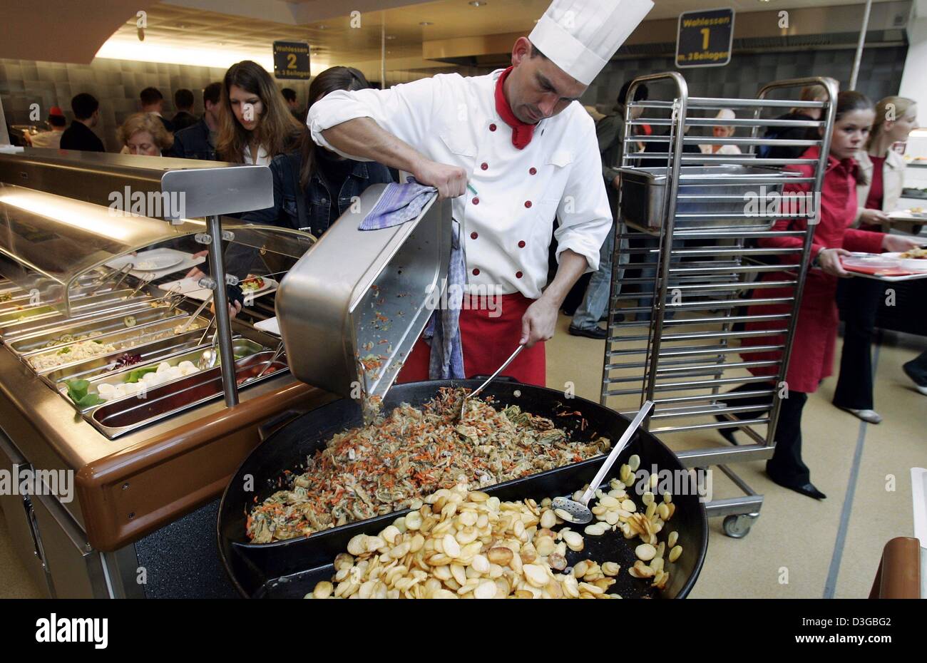 (dpa) - Cook Olaf Kellmann refills a large pan of noodles and potatoes ...