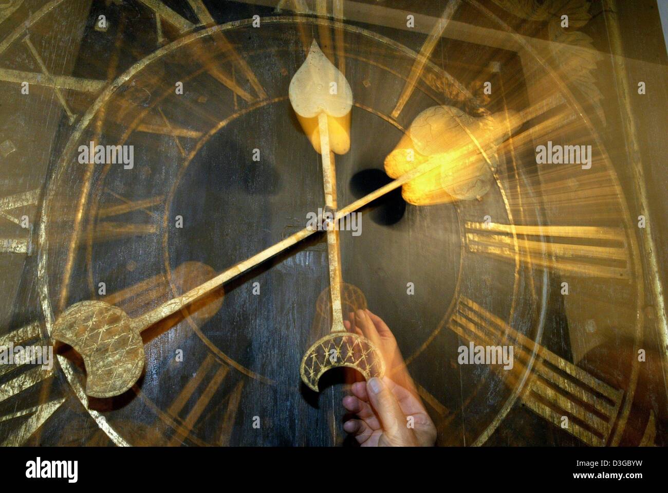 A hand changes the needle at the dial of a convent clock from the ...
