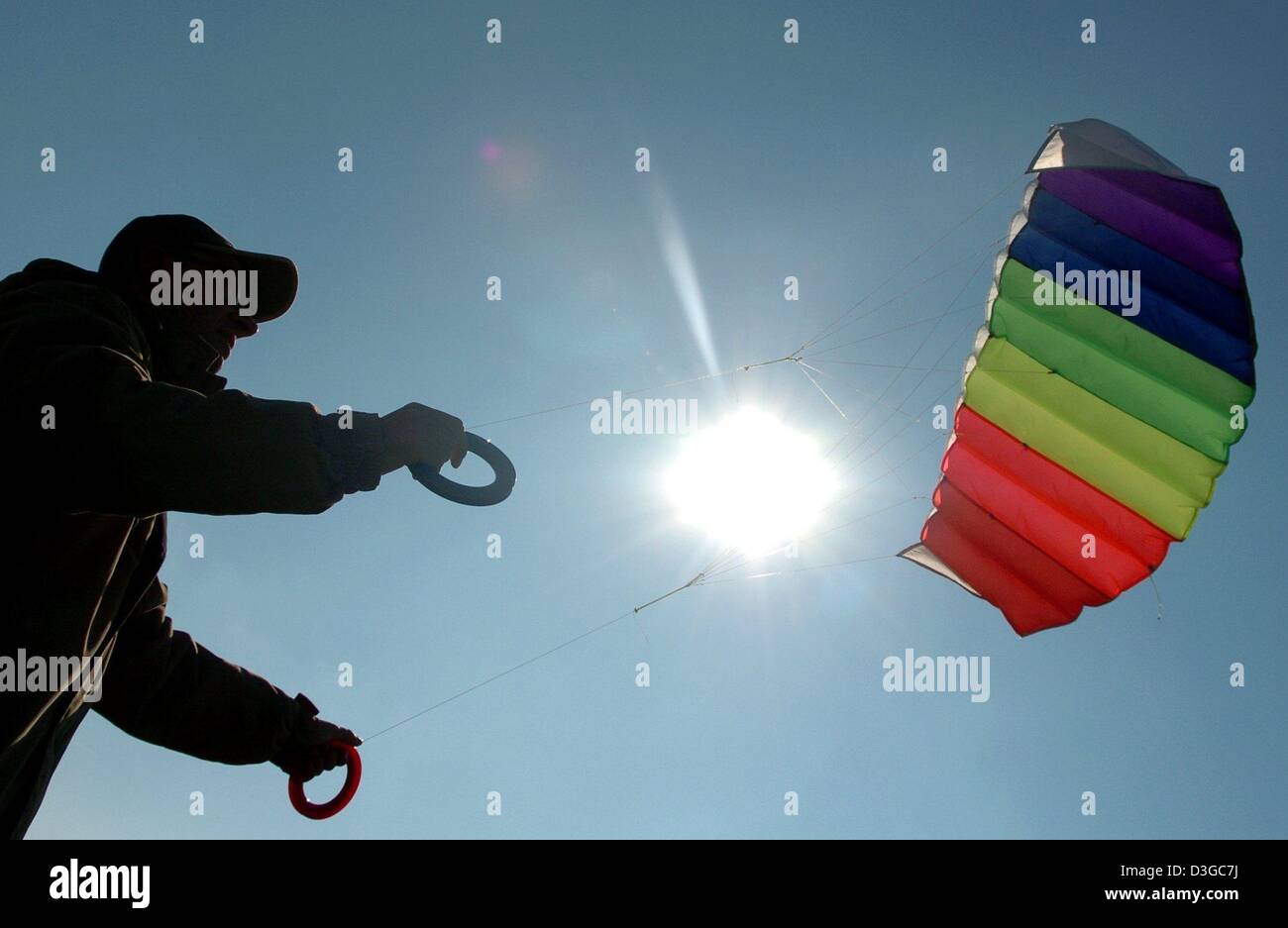 (dpa) - A man flies a kite while enjoying the sunny, cold and windy ...