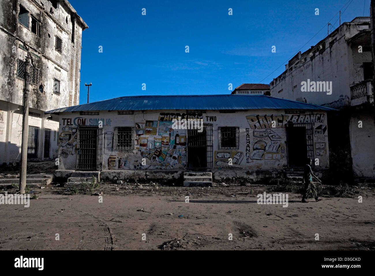 A man walks past an empty disused building in downtown Mogadishu Stock ...