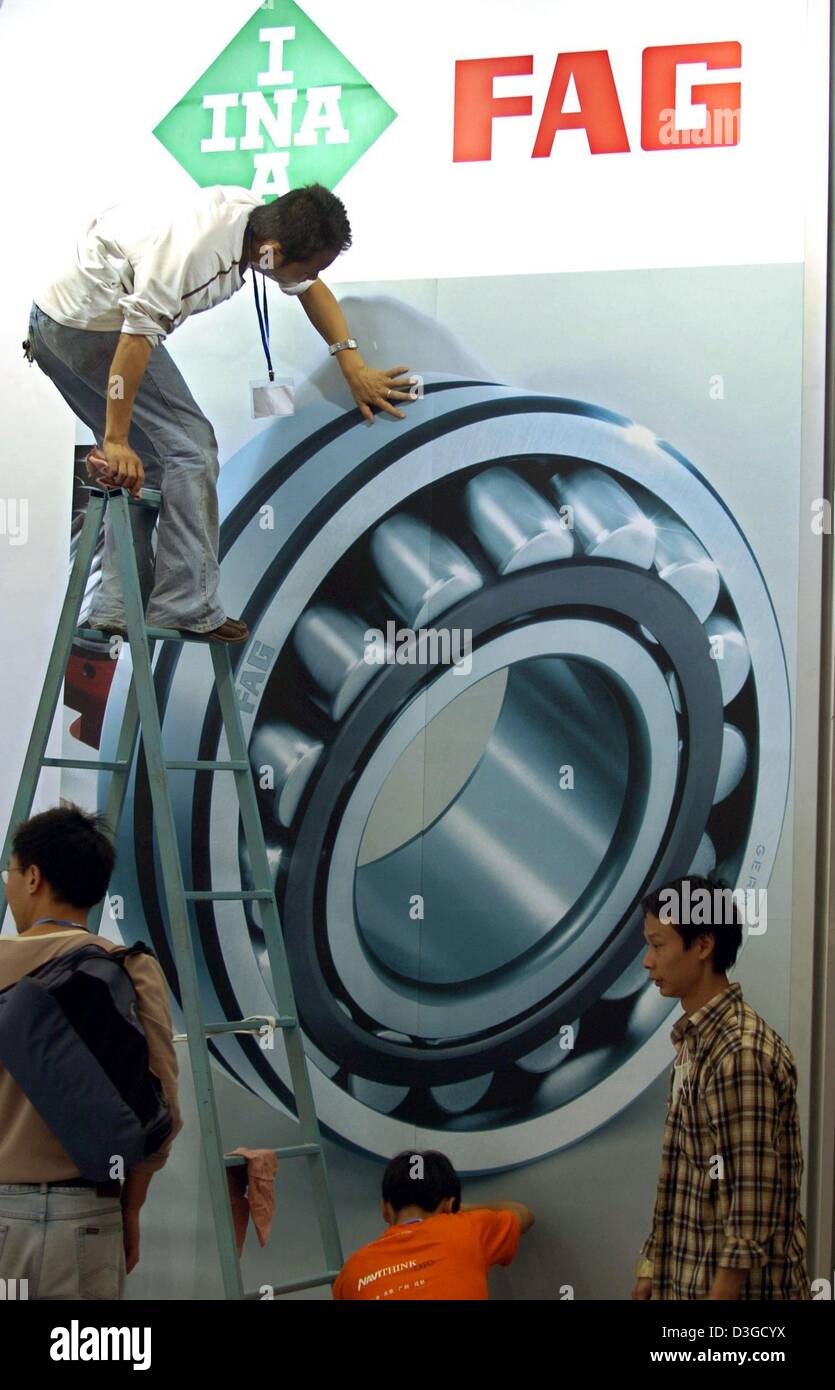 (dpa) - Chinese booth builders attach a poster on a trade fair booth ...