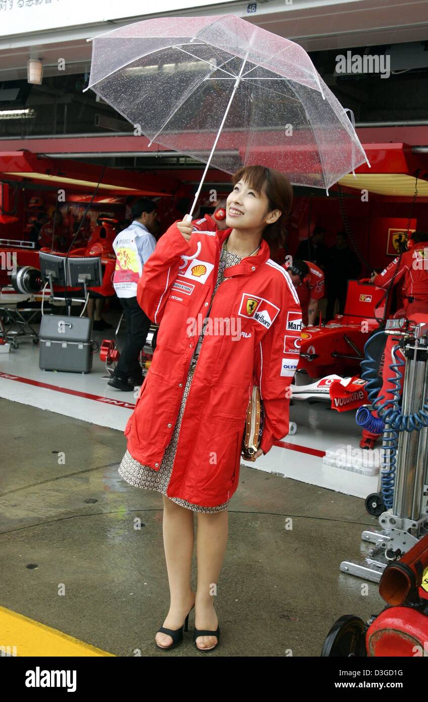 (dpa) - A Ferrari hostess with an umbrella stands in the rain during ...