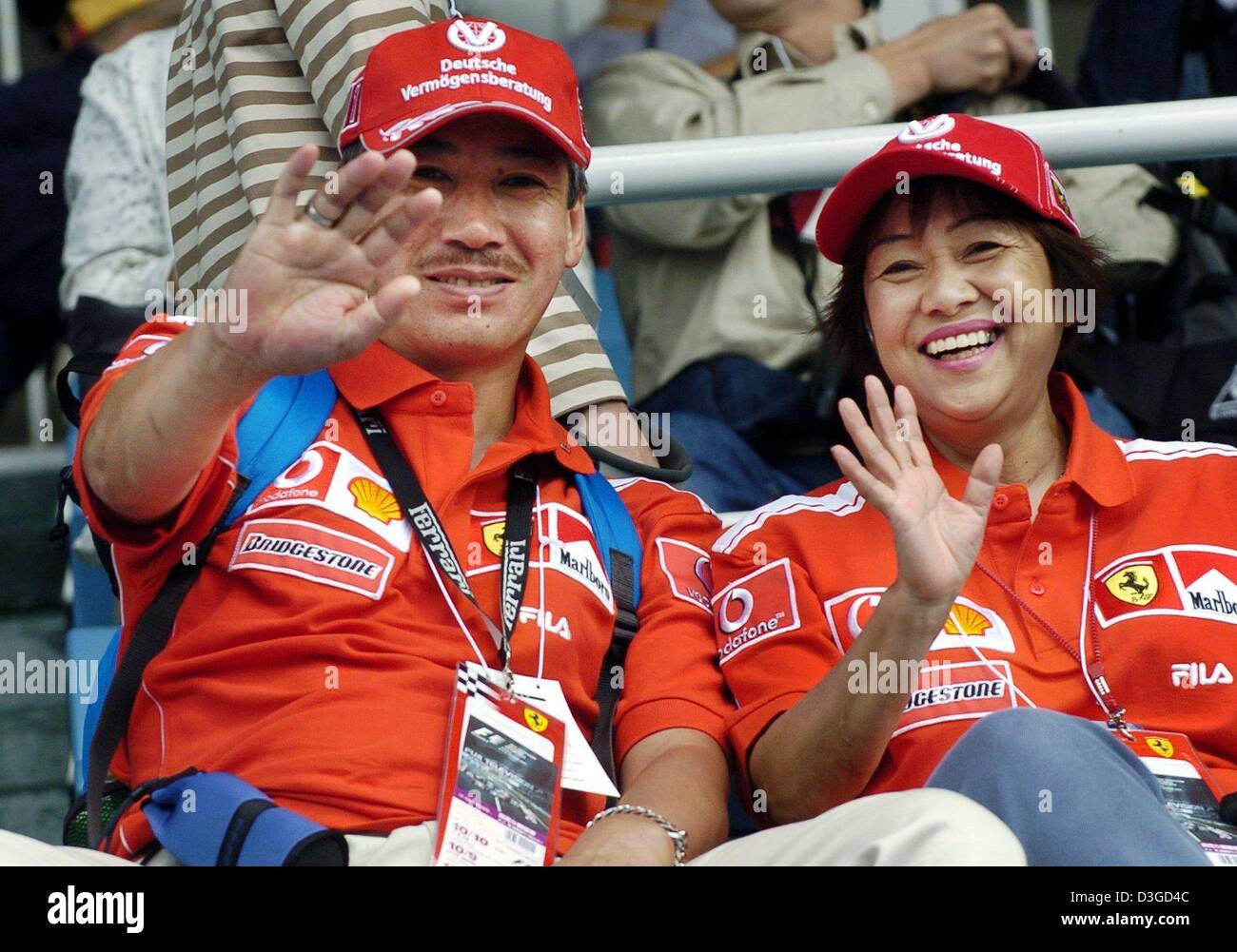 (dpa) - Japanese Ferrari fans wave into camera on the racing circuit in ...