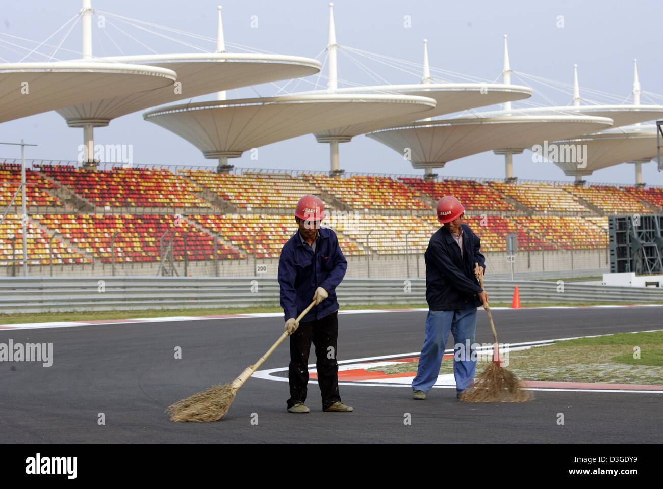 (dpa) - Workers clean the track with brooms at the new Shanghai ...