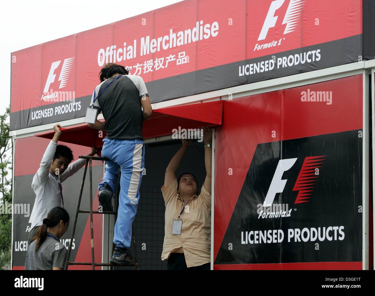 (dpa) - Workers put up a sales booth for fan articles on the formula ...