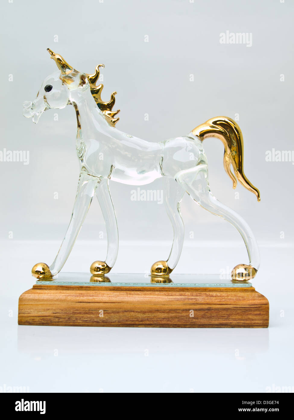 A glass horse on wooden platform isolated on white Stock Photo - Alamy