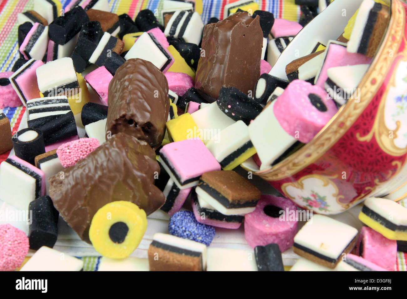 Lots of liquorice sweets and chocolate rolls spilling from an upturned ...