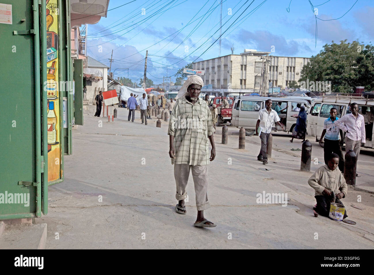 A man walks past a set of open shops on the busy streets of Mogadishu ...