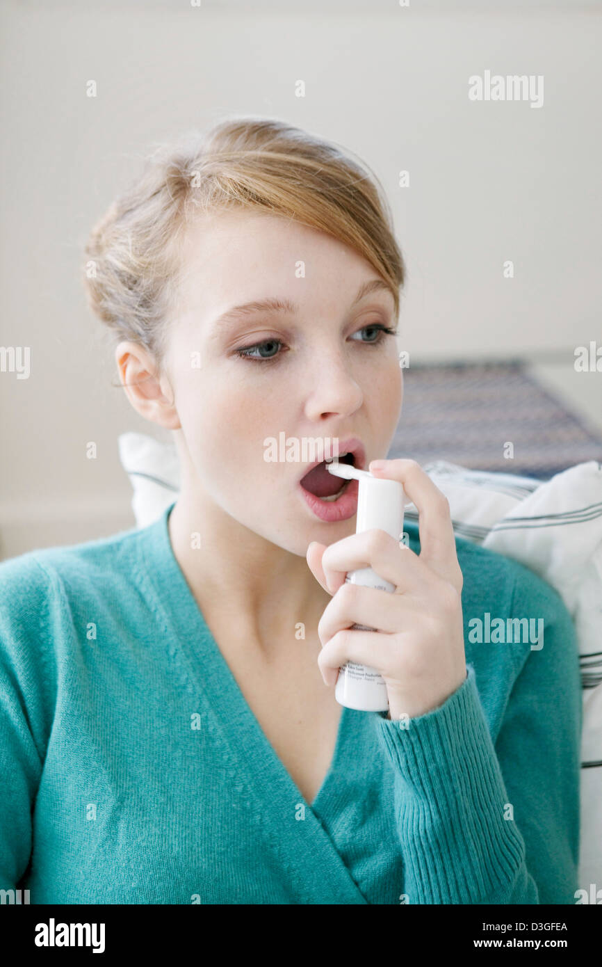 WOMAN USING SPRAY IN MOUTH Stock Photo - Alamy