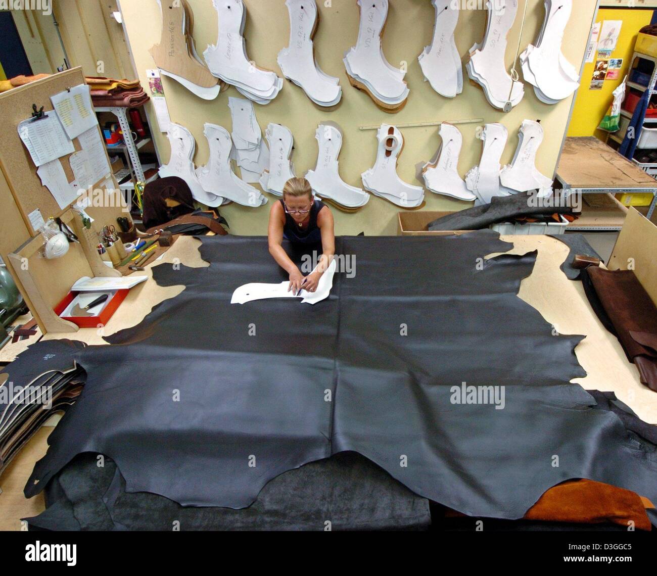 (dpa) - An employee marks leather with a template at the Passier and ...
