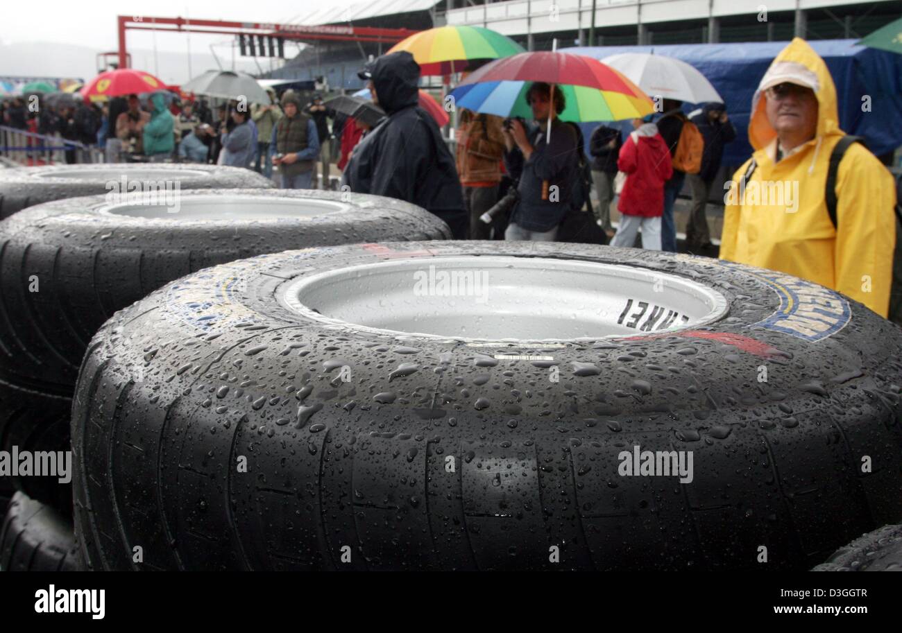 (dpa) - In pouring rain walk Formula 1 fans through the pit lane at the ...