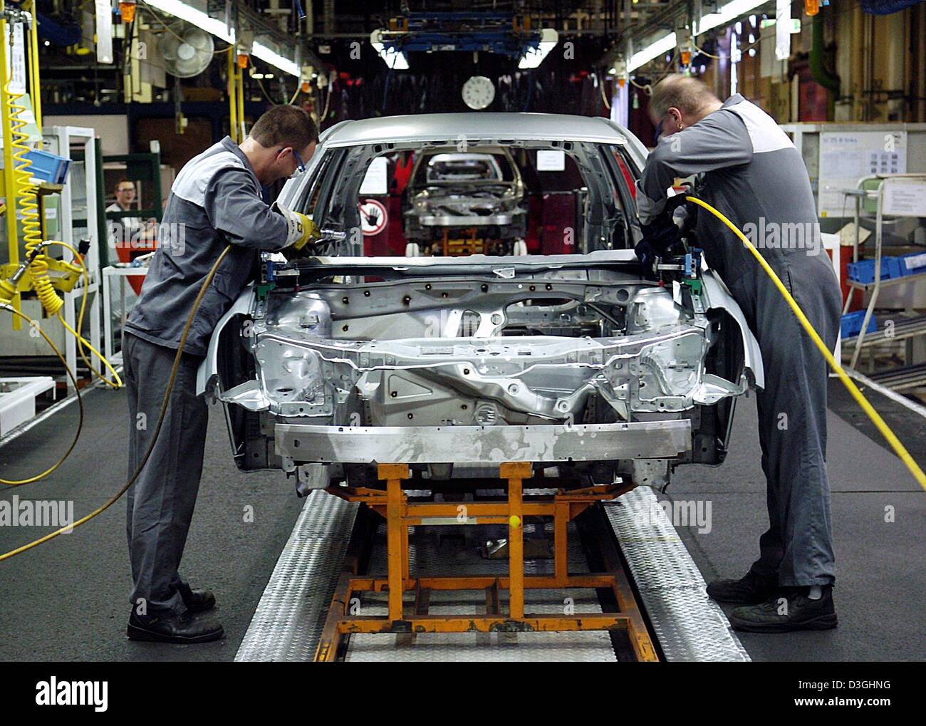 (dpa) - Workers with a car body of the Opel Astra Caravan at the Opel ...