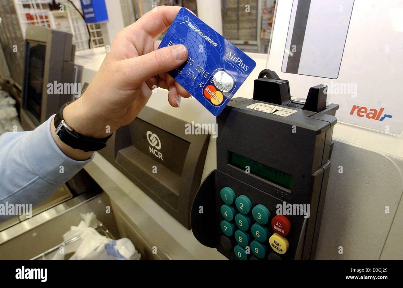 (dpa) - A customer at a supermarket pays for her groceries with her ...
