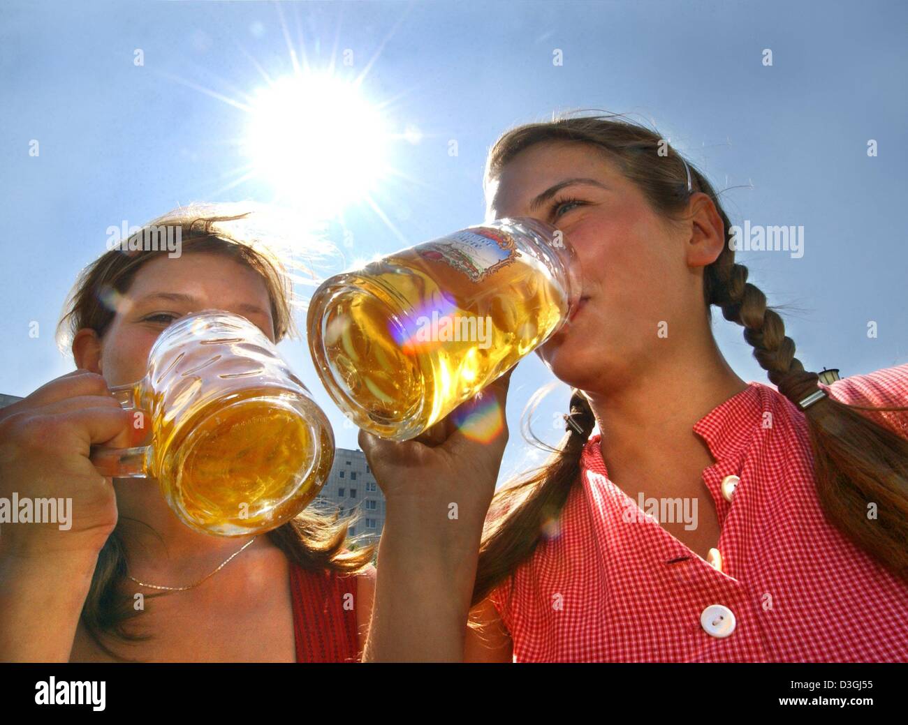 (dpa) - Two women drink cold beer from large mugs in Berlin, Germany, 6 ...