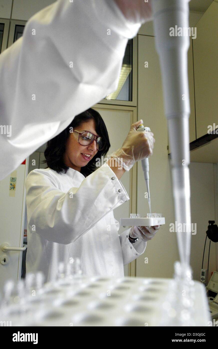 (dpa) - Employees pipette a solution into test tubes at the research ...