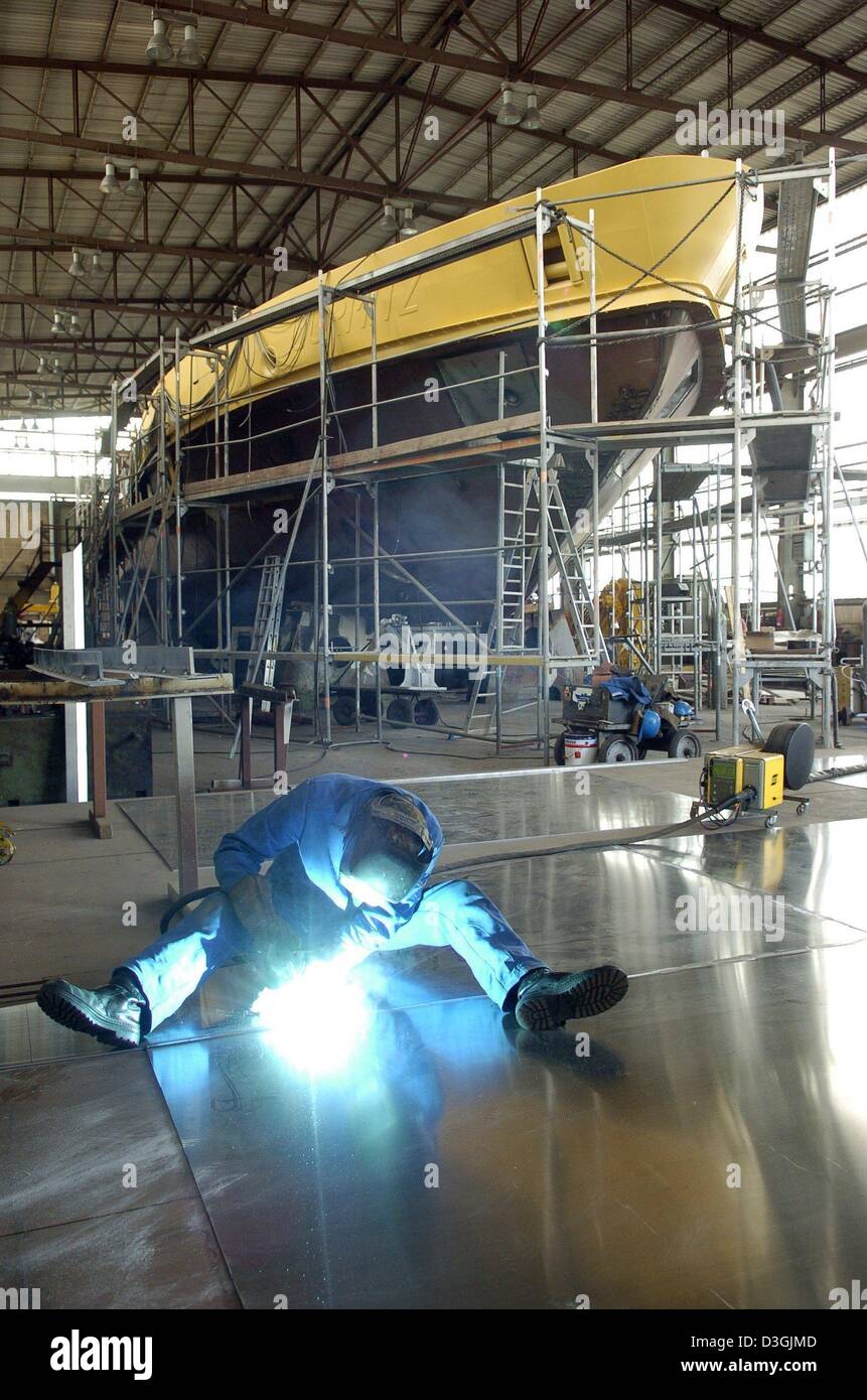 (dpa) - A boatbuilder at work welding two metal plates together at the ...