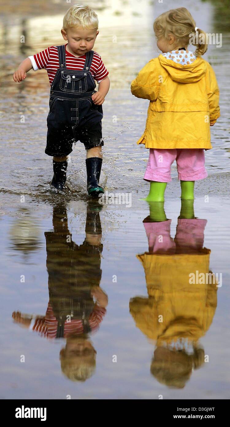 Human interest hum people puddle water children kids playing germany hi ...
