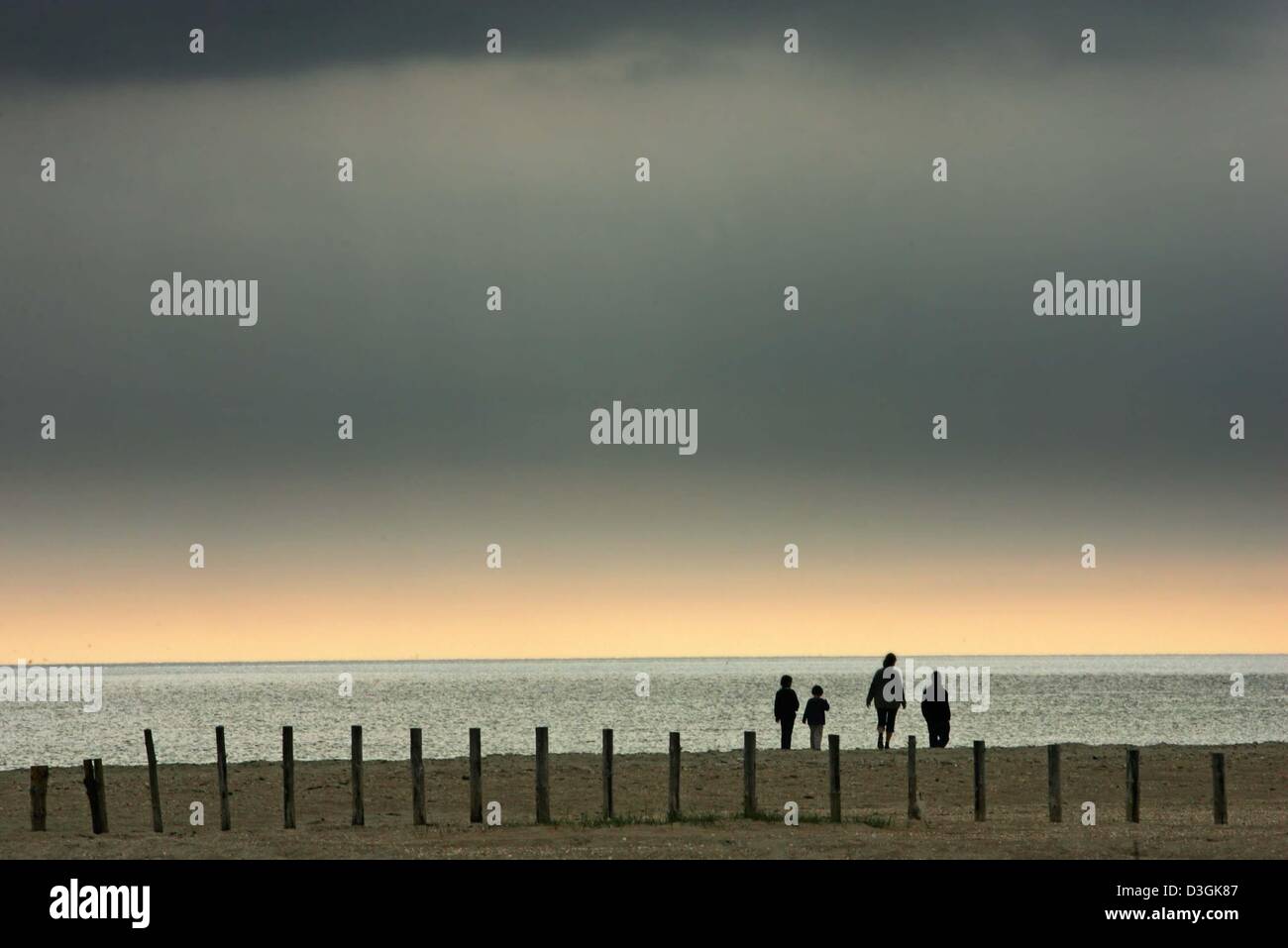 (dpa) - A family walks along the beach on the Danish North Sea island ...