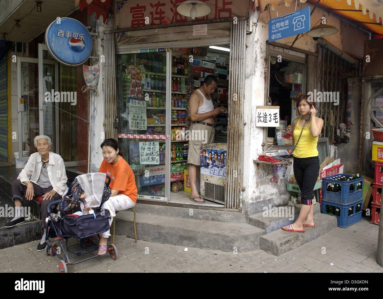 (dpa) - A group of people stand around a corner shop in the old Dong ...