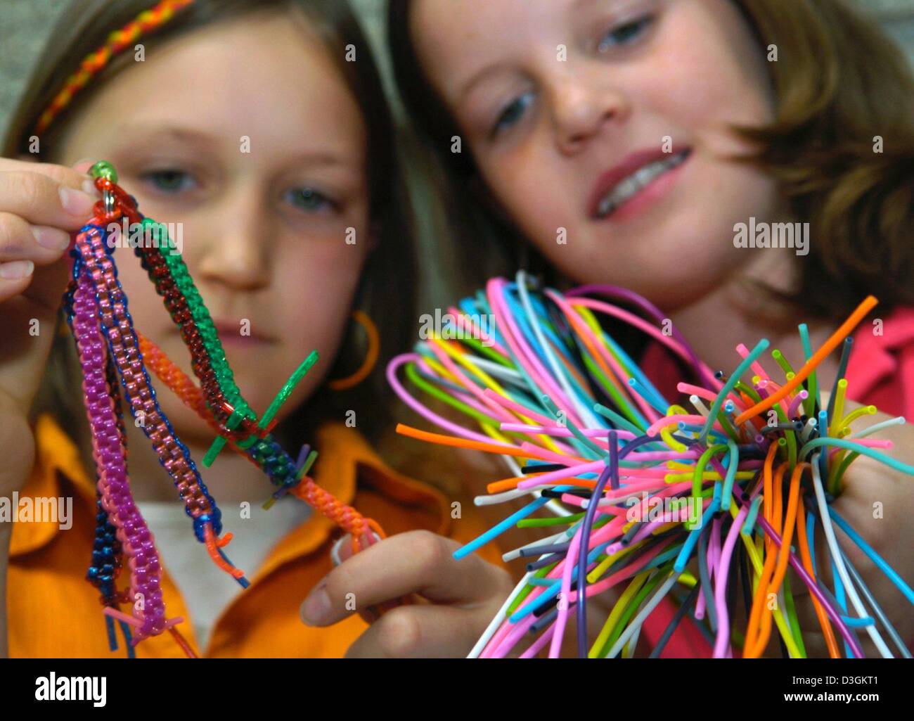 (dpa) - School girl Marlen (L) shows a collection of key fobs woven ...