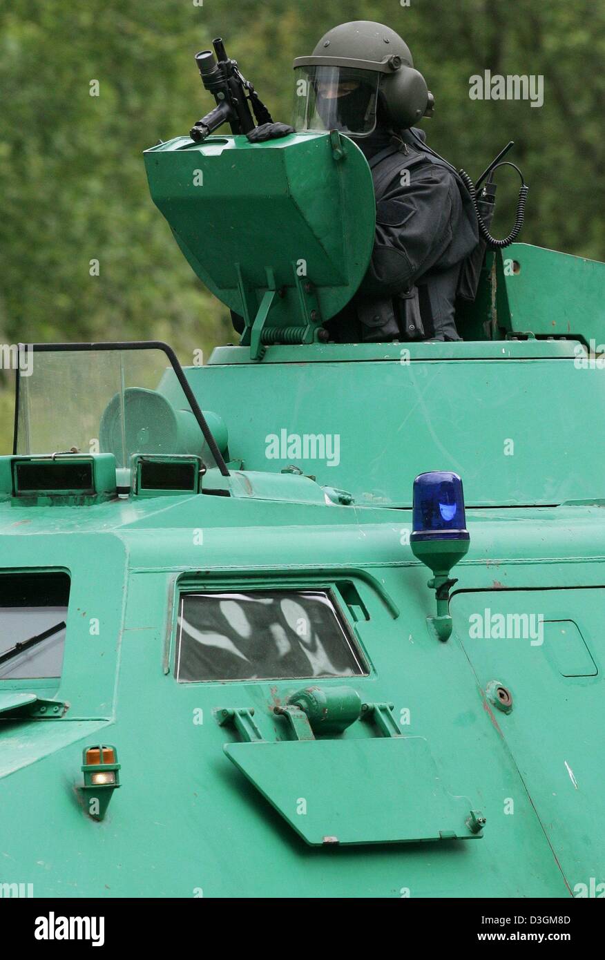 (dpa) - A police officer from a special forces unit looks out of an ...