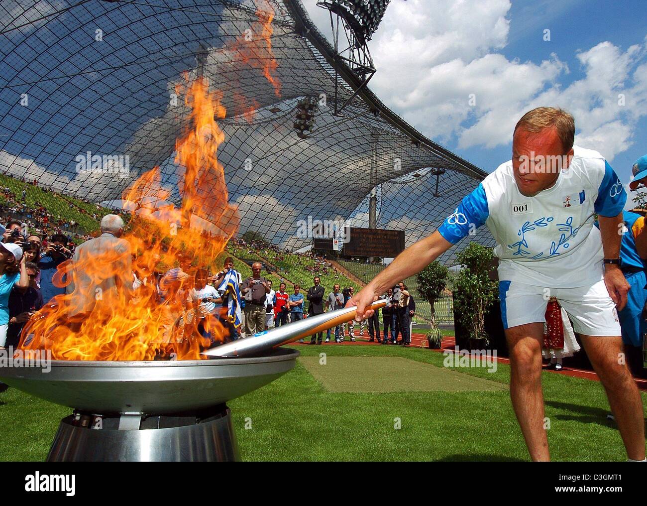 (dpa) - Guenter Zahn lights the torch with the Olympic flame in a ...